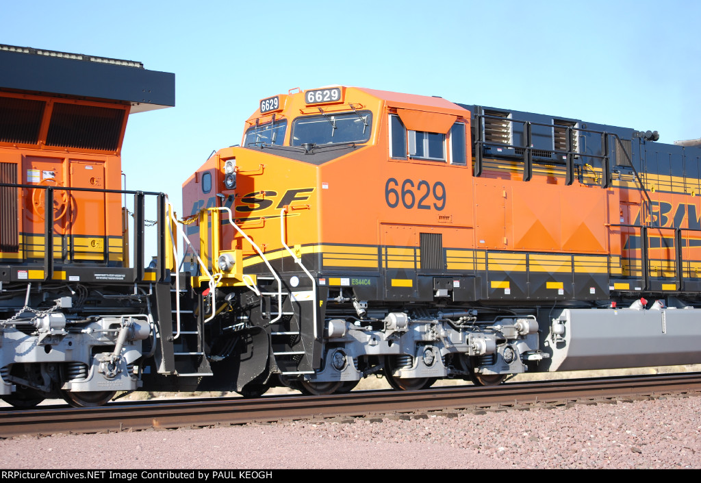 BNSF 6629 starts to pull west as the sun's rays glow off her Brand New Swoosh Logo.